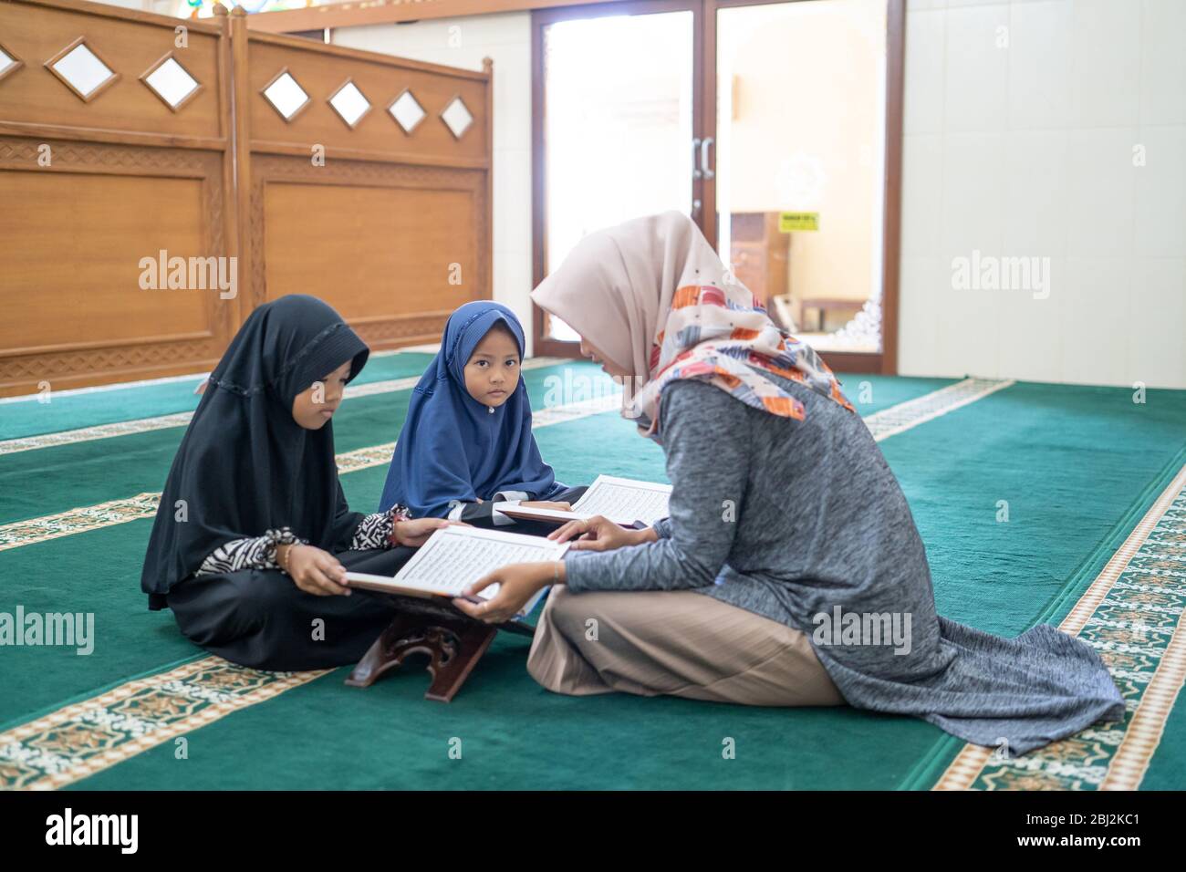 muslim young female teacher teach her student to read quran in the ...