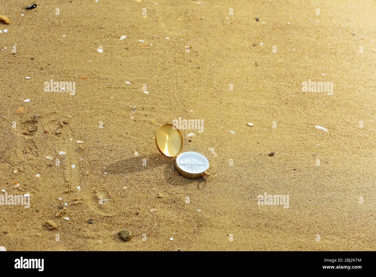 Compass on sand beach background Stock Photo - Alamy