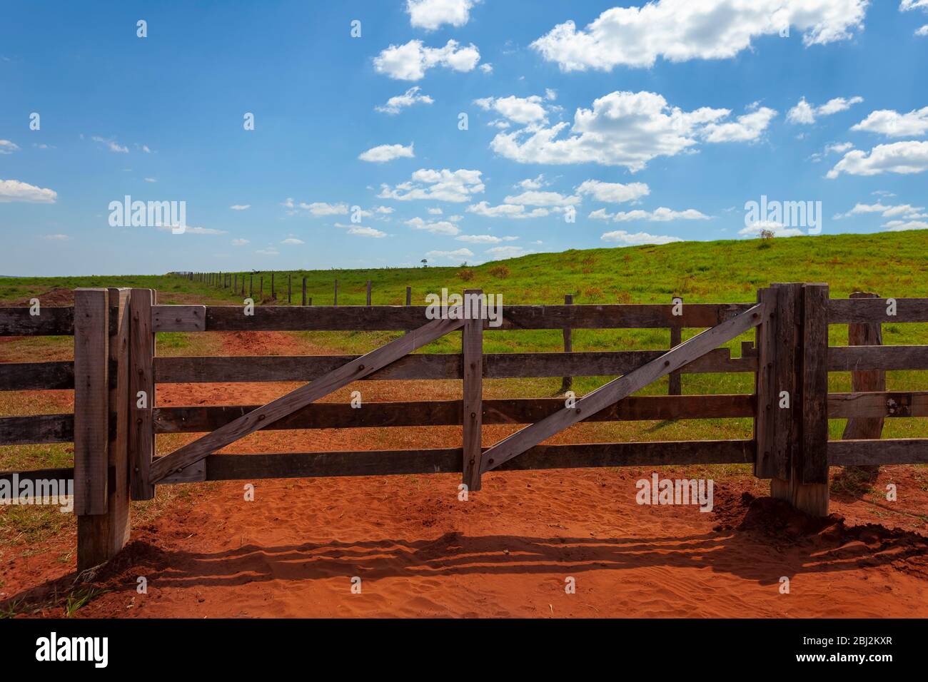 closed farm gate under blue sky with clouds Stock Photo - Alamy