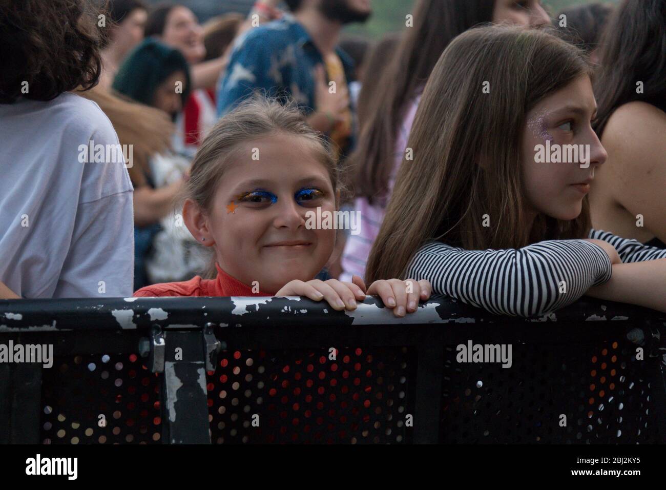 Audience with hands raised at a music festival and lights streaming ...