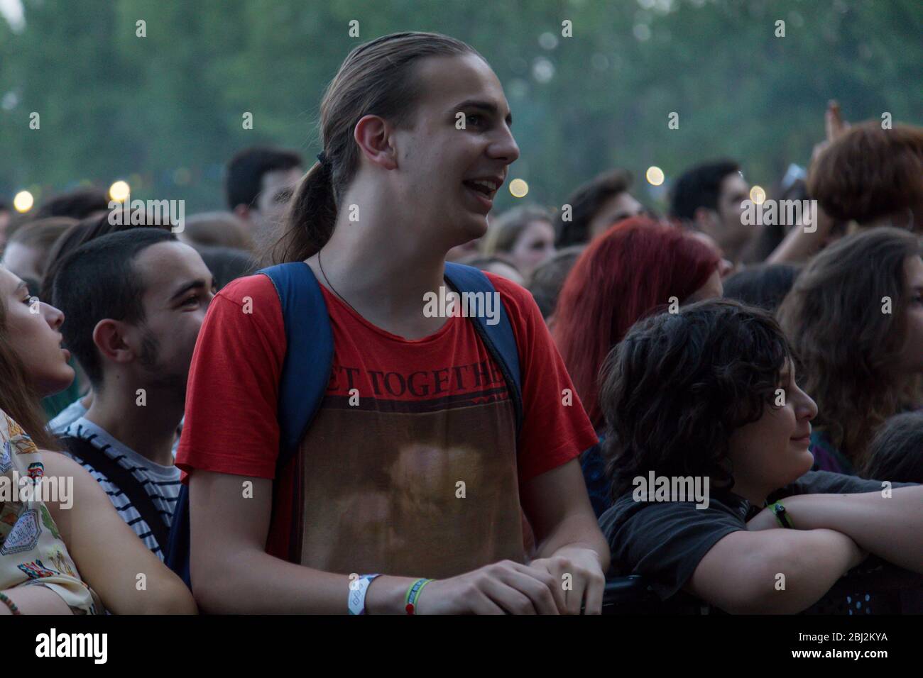 Audience with hands raised at a music festival and lights streaming ...