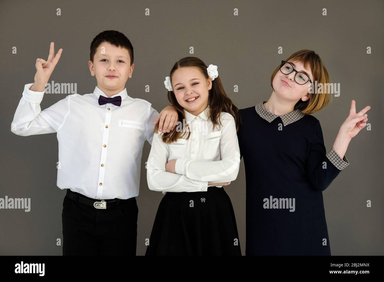 best school friends: girls and boys. Happy grinning classmates stand ...