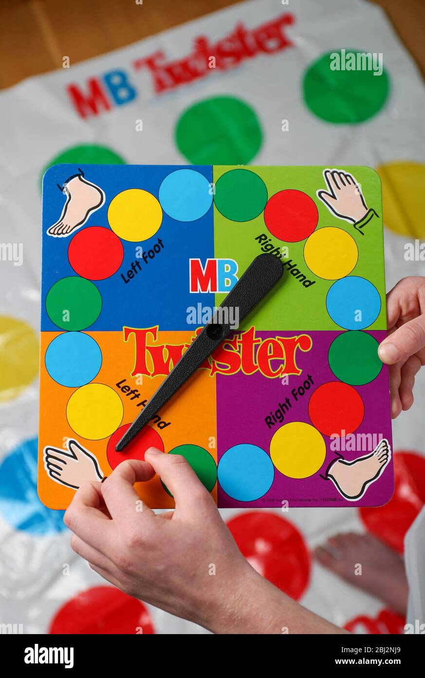 A boy spinning the twister game spinner before his go on the mat Stock ...