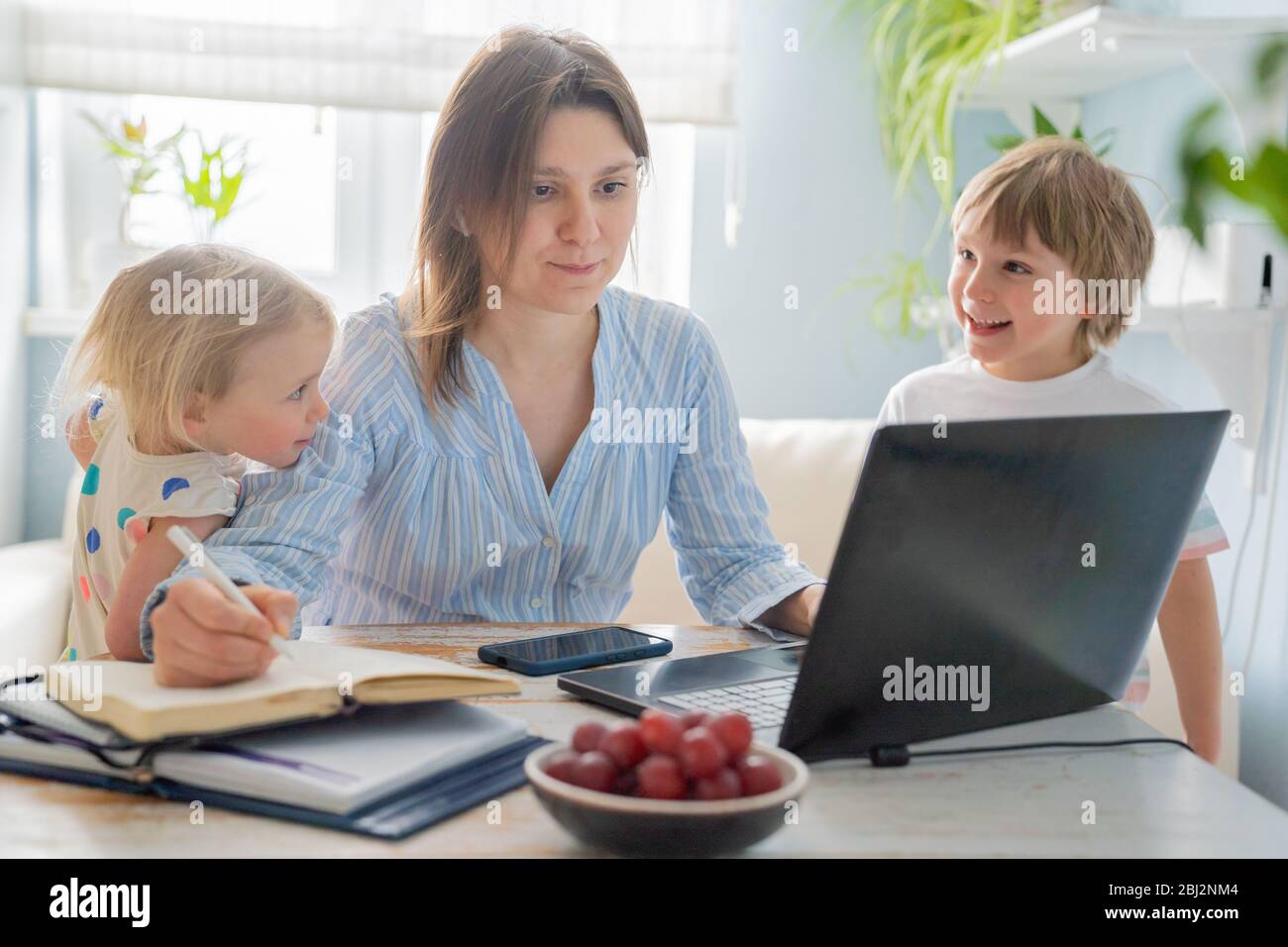 Female working from home with kids running and screaming Stock Photo ...