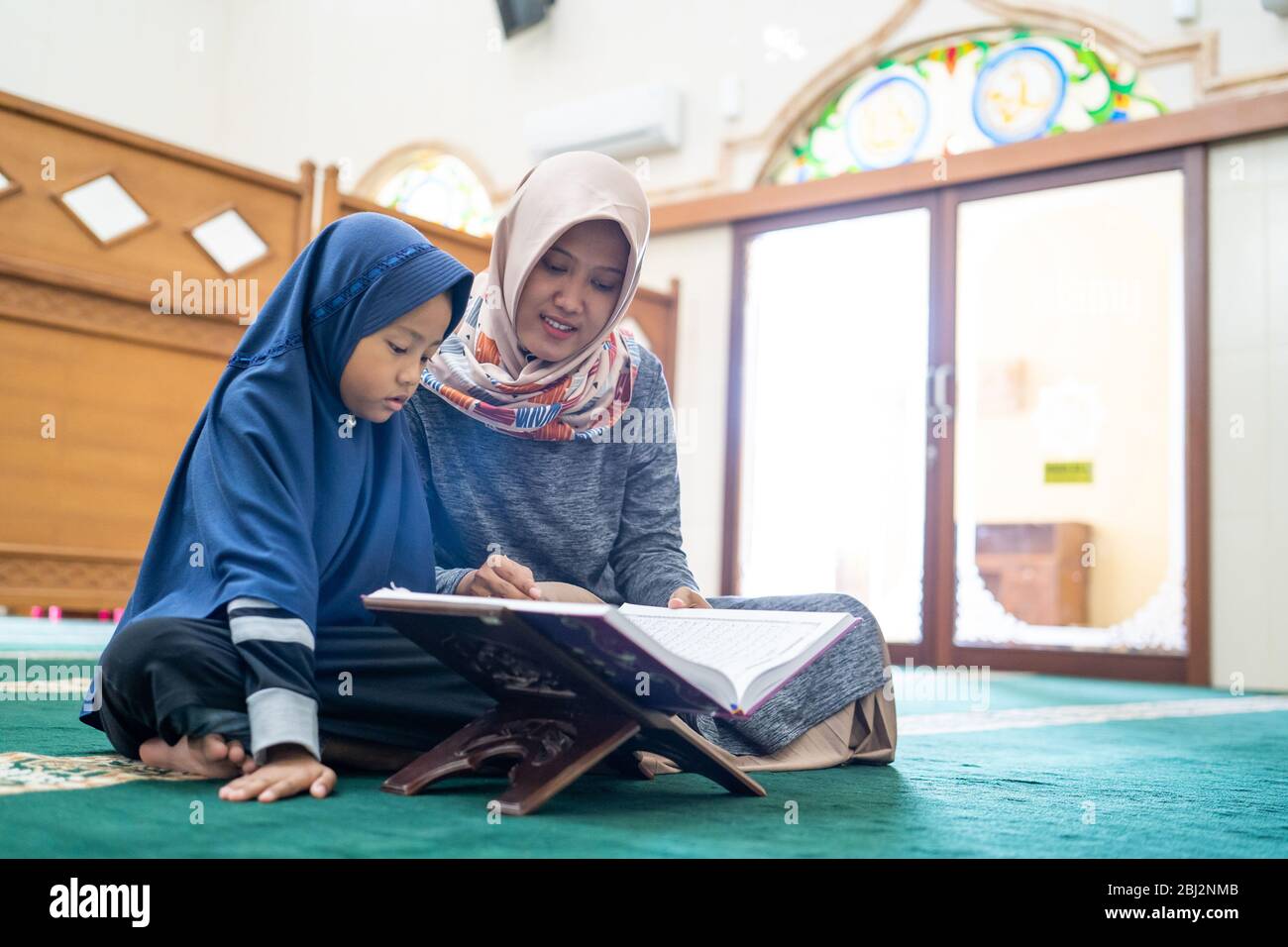 muslim young female teacher teach her student to read quran in the ...