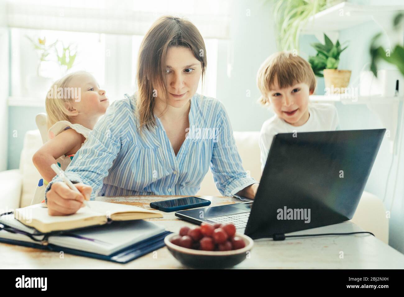 Female working from home with kids running and screaming Stock Photo ...