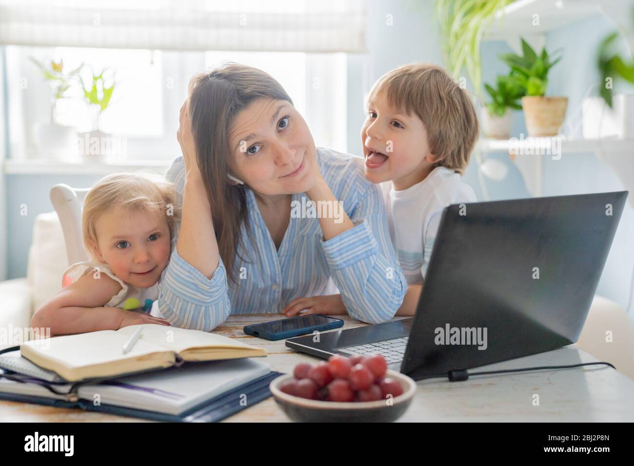 Female working from home with kids running and screaming Stock Photo ...