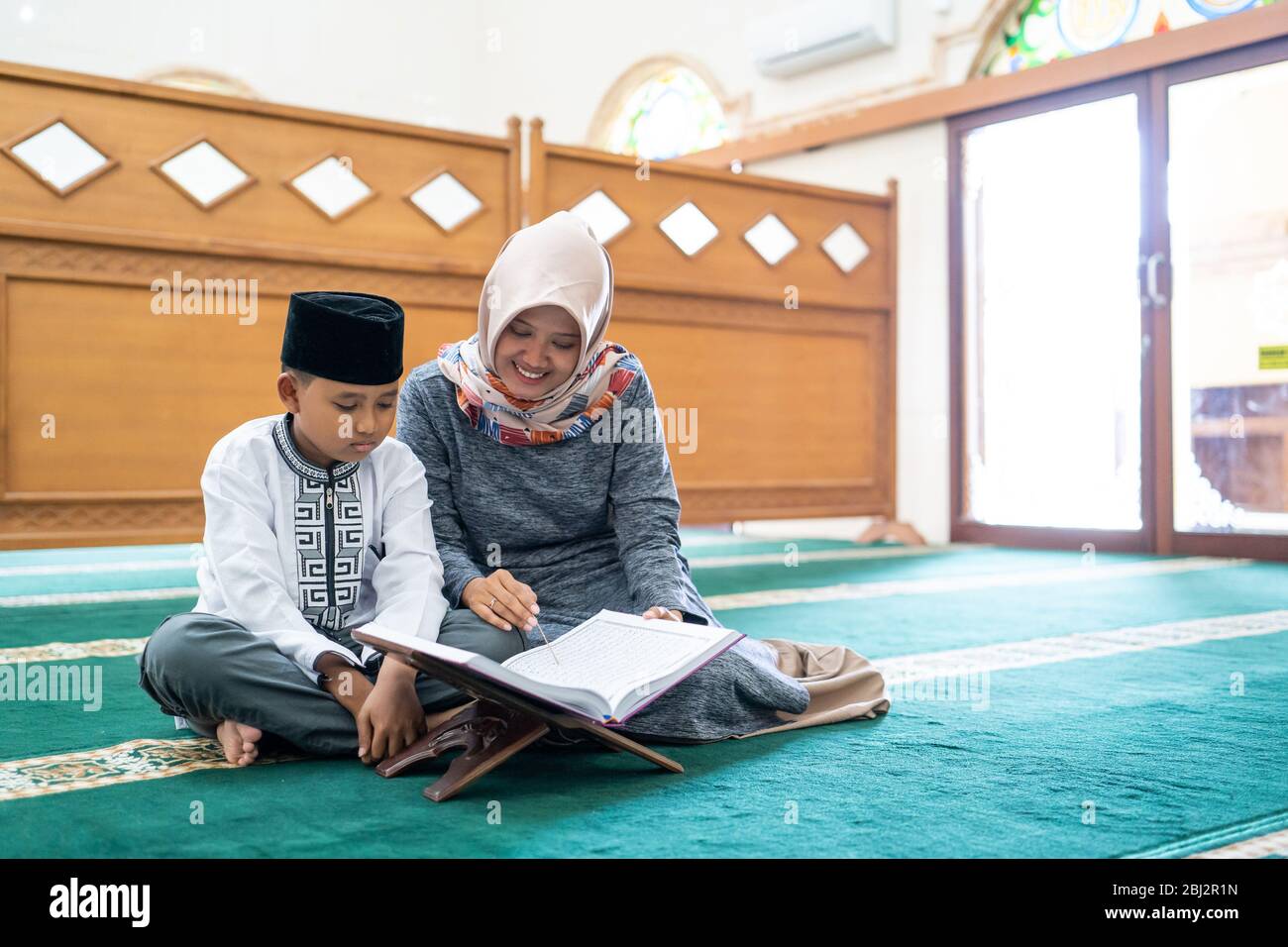 kid learning to read quran with muslim teacher or ustad Stock Photo - Alamy