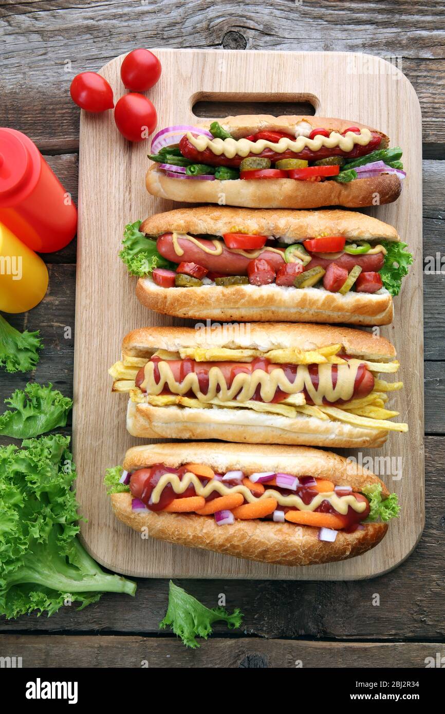 Fresh hot dogs on cutting board and bottles on wooden background Stock ...
