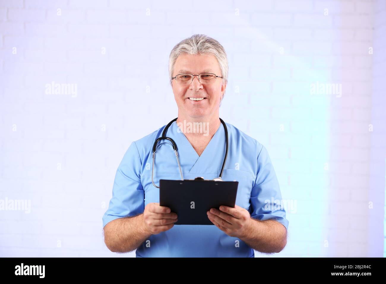 Doctor with clipboard on light blue background Stock Photo - Alamy