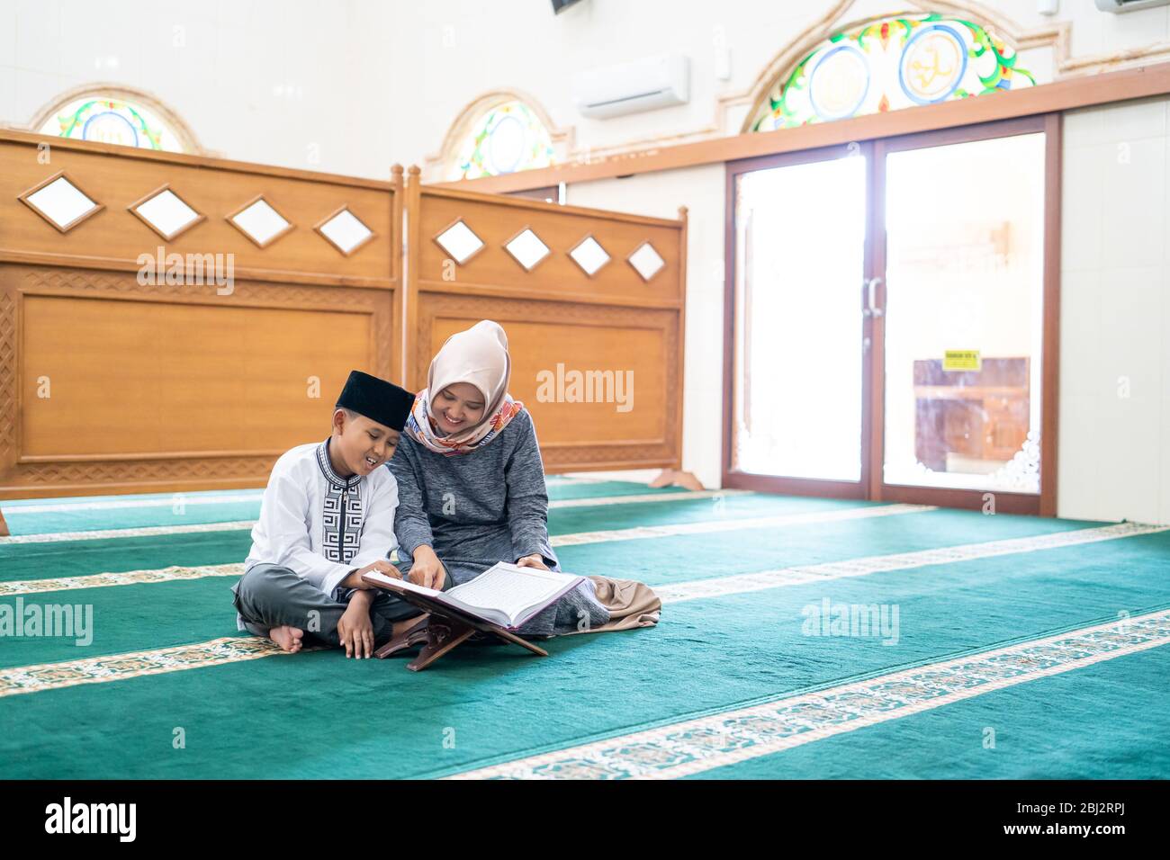 kid learning to read quran with muslim teacher or ustad Stock Photo - Alamy