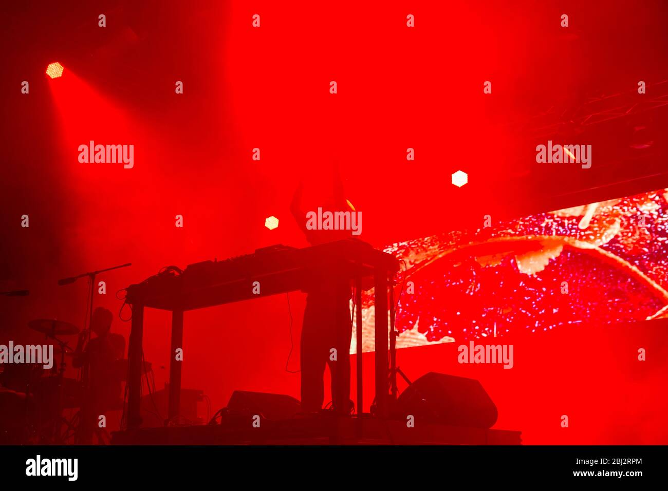 Audience with hands raised at a music festival and lights streaming ...