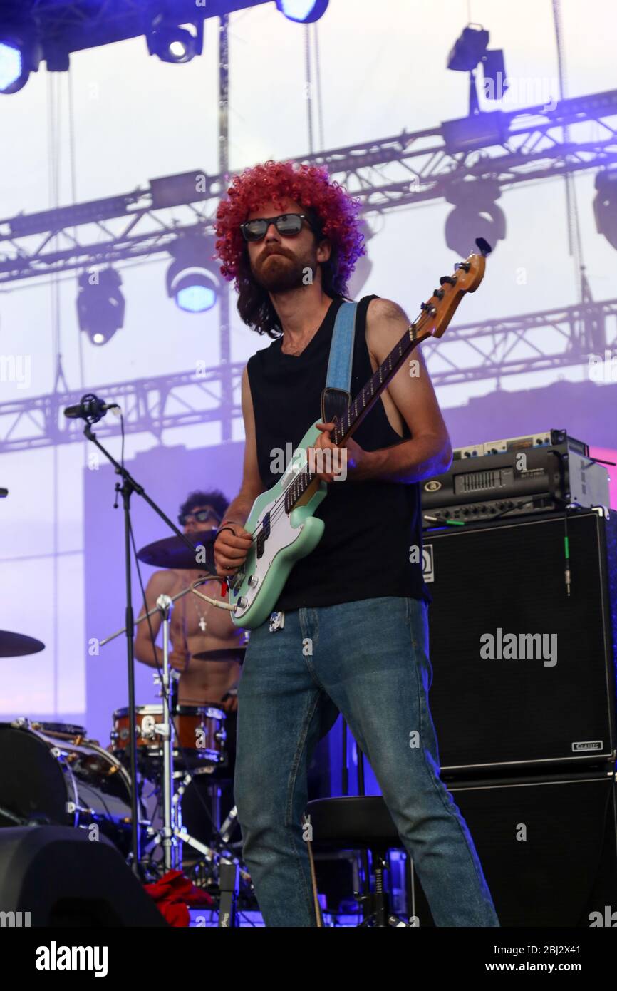 Audience with hands raised at a music festival and lights streaming ...