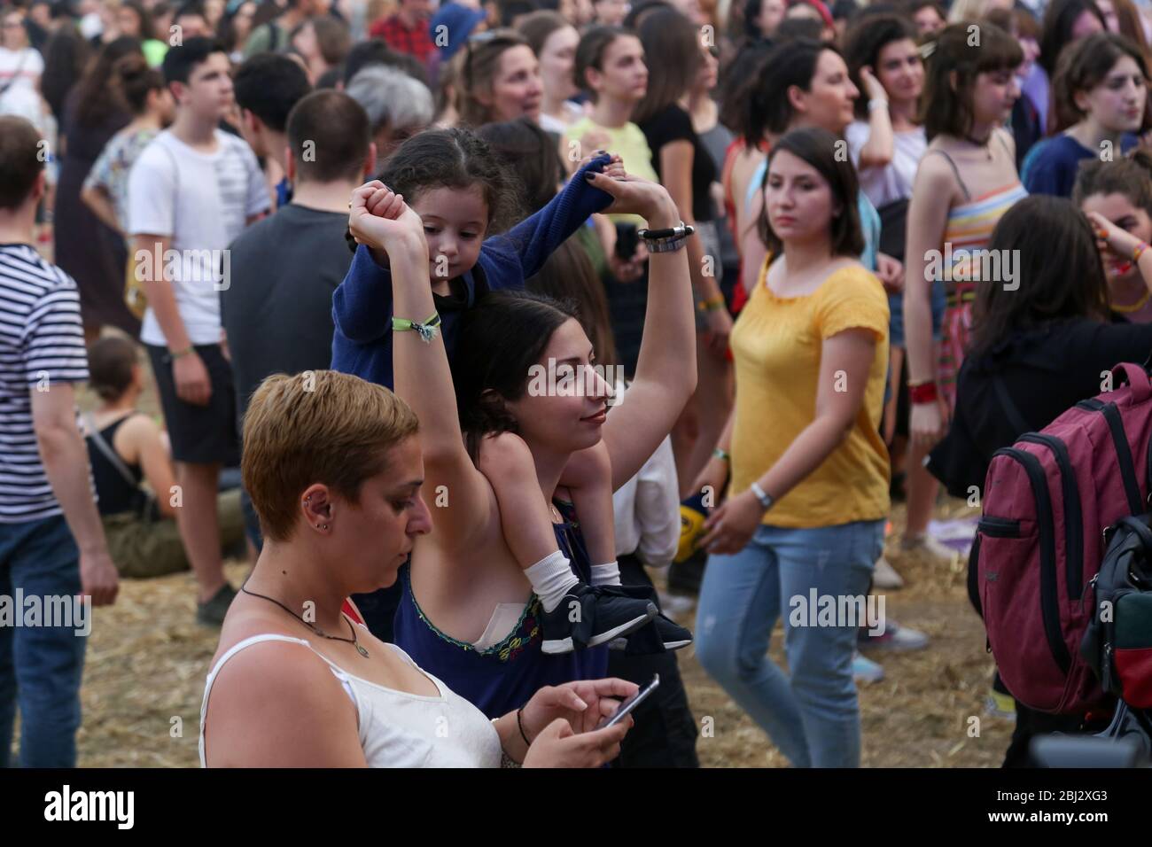 Audience with hands raised at a music festival and lights streaming ...
