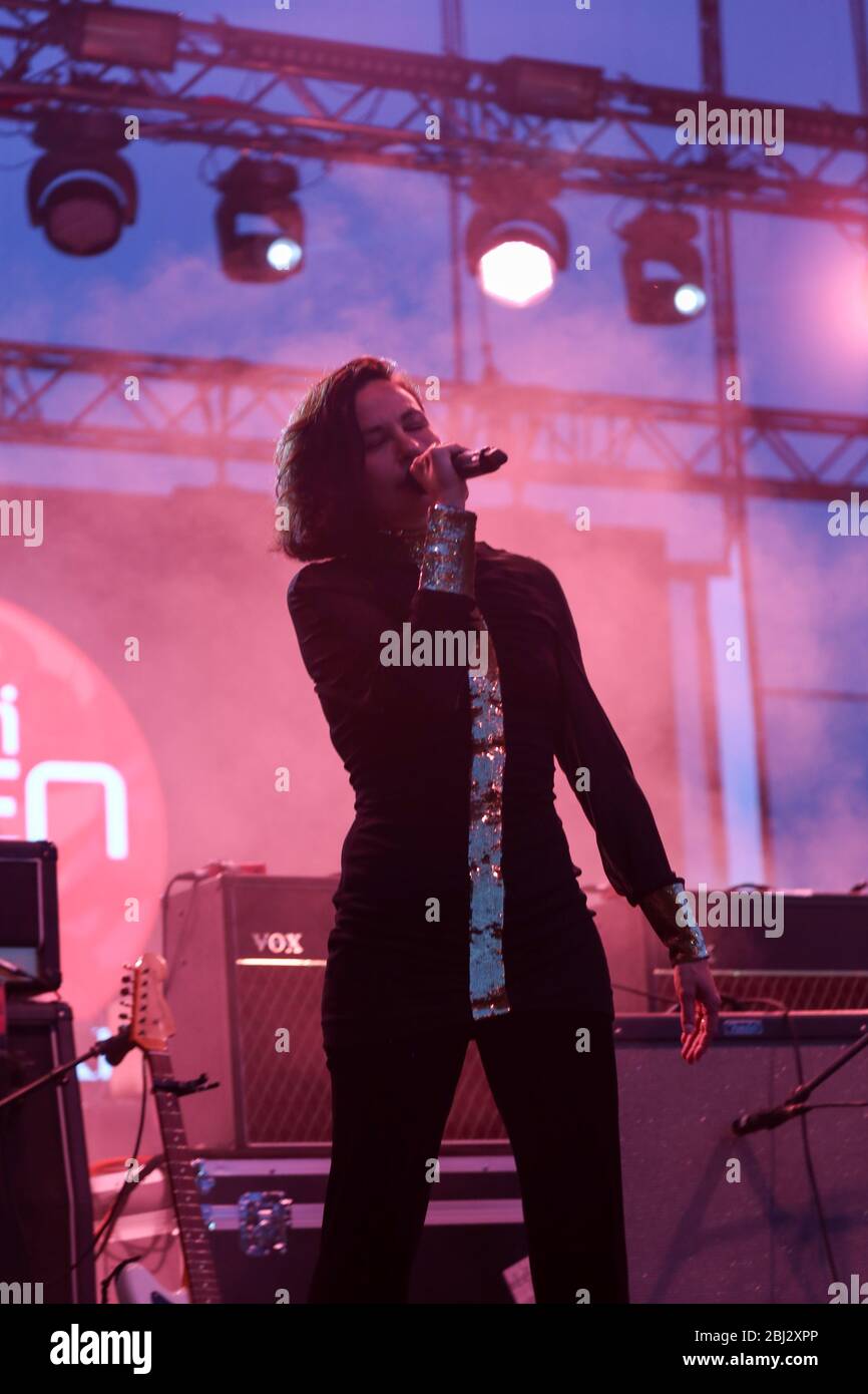 Audience with hands raised at a music festival and lights streaming ...