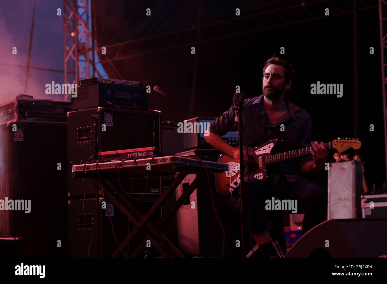 Audience with hands raised at a music festival and lights streaming ...