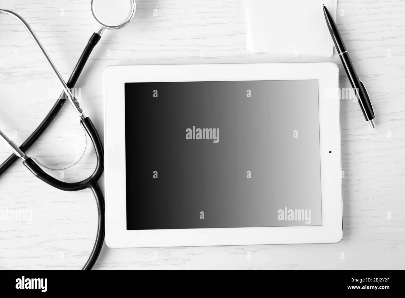 Medical tablet with screen empty screen on wooden table Stock Photo - Alamy