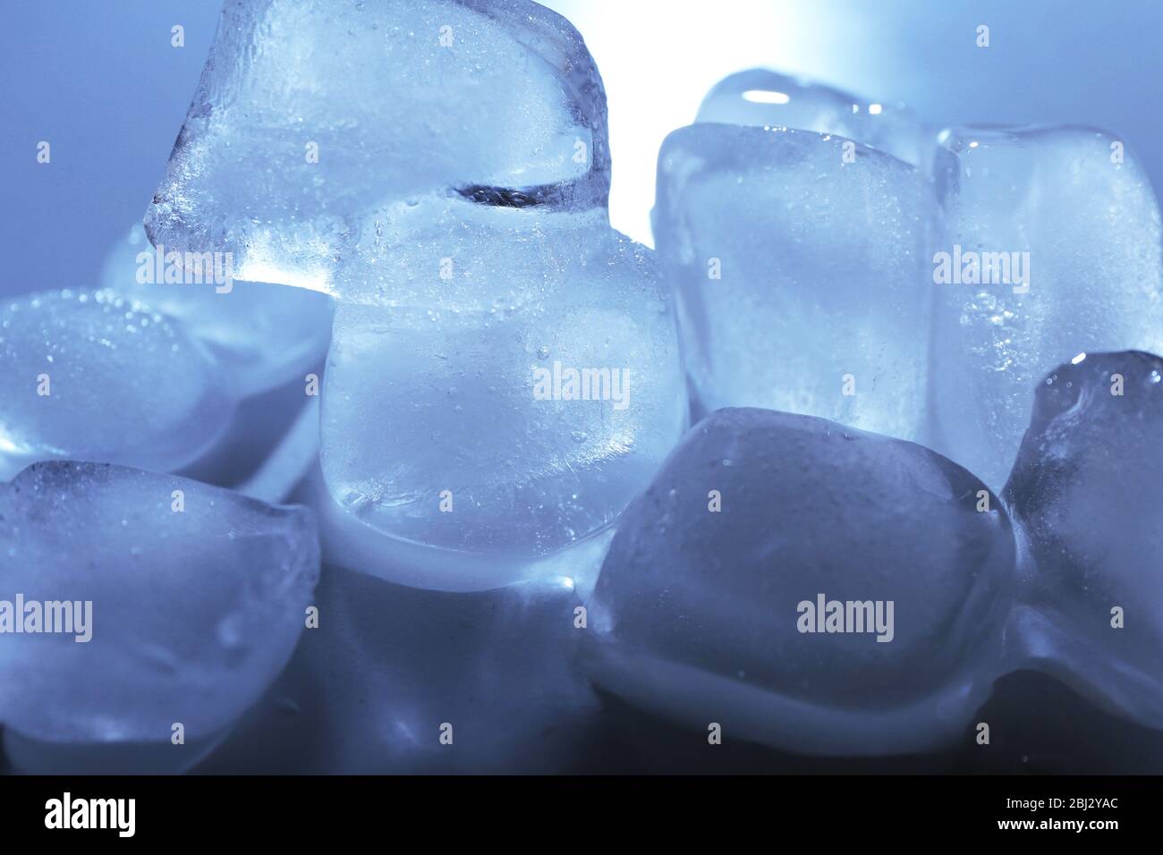 White ice cubes under blue light, close up Stock Photo - Alamy