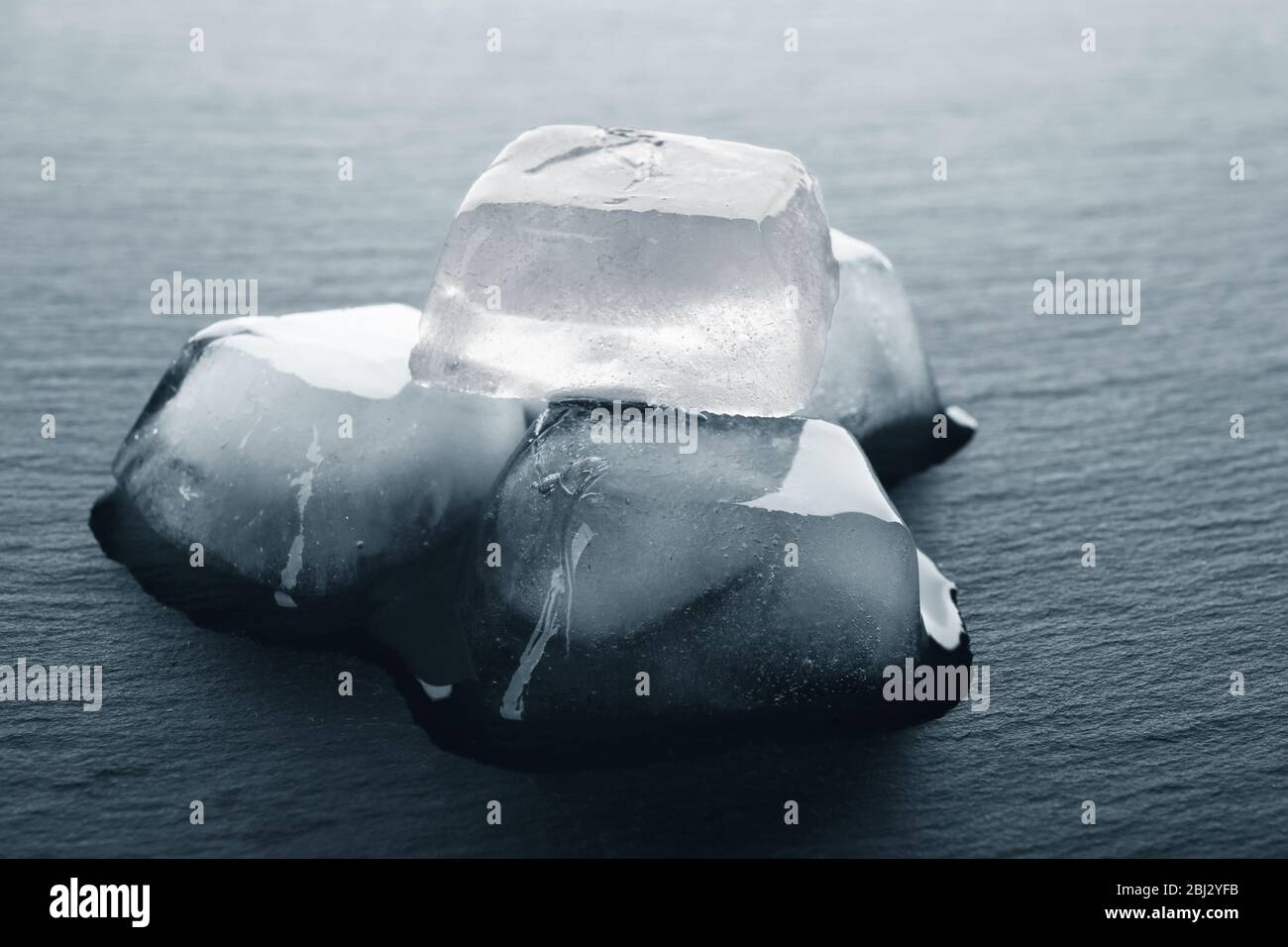 Matted ice cubes on dark liquid background Stock Photo - Alamy
