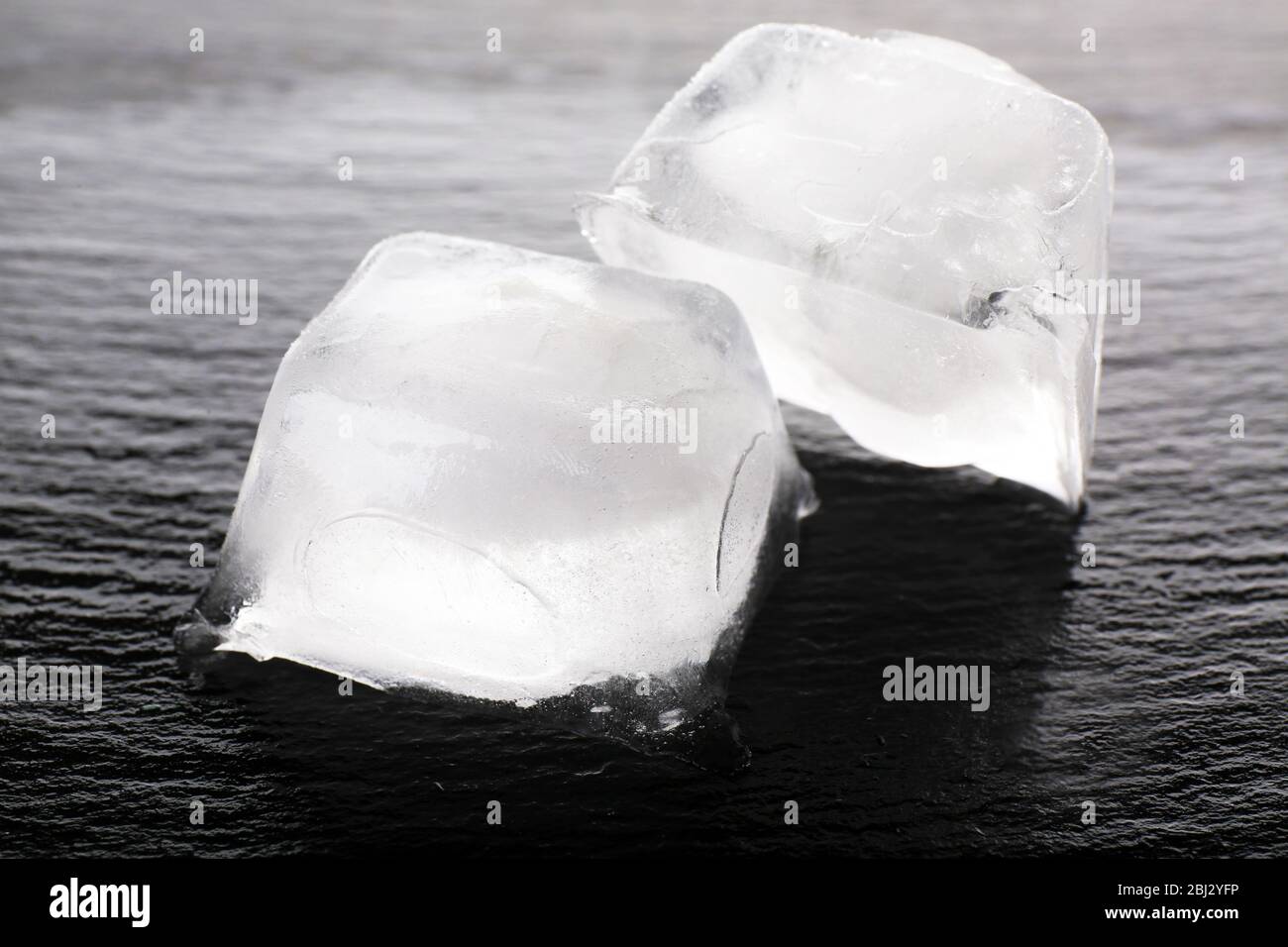Matted ice cubes on dark liquid background Stock Photo - Alamy