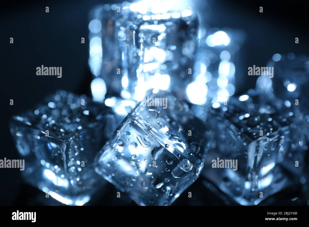 Shining ice cubes under blue light on liquid background Stock Photo - Alamy