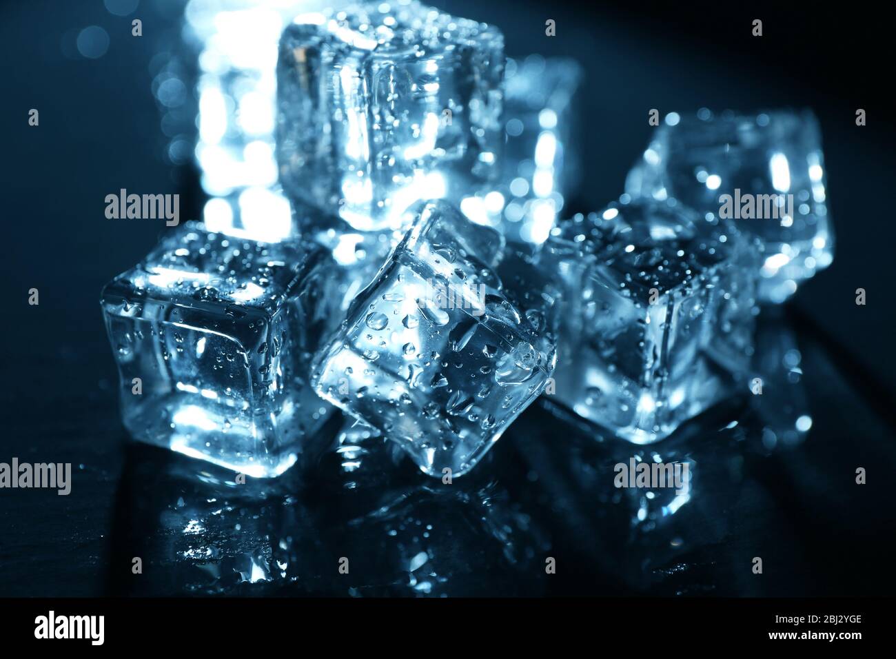 Shining ice cubes under blue light on liquid background Stock Photo - Alamy