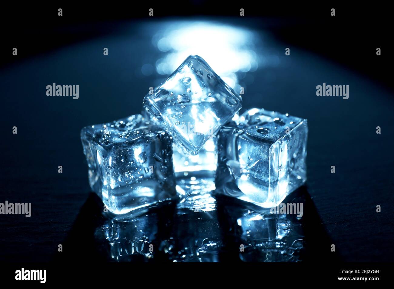 Shining ice cubes under blue light on liquid background Stock Photo - Alamy