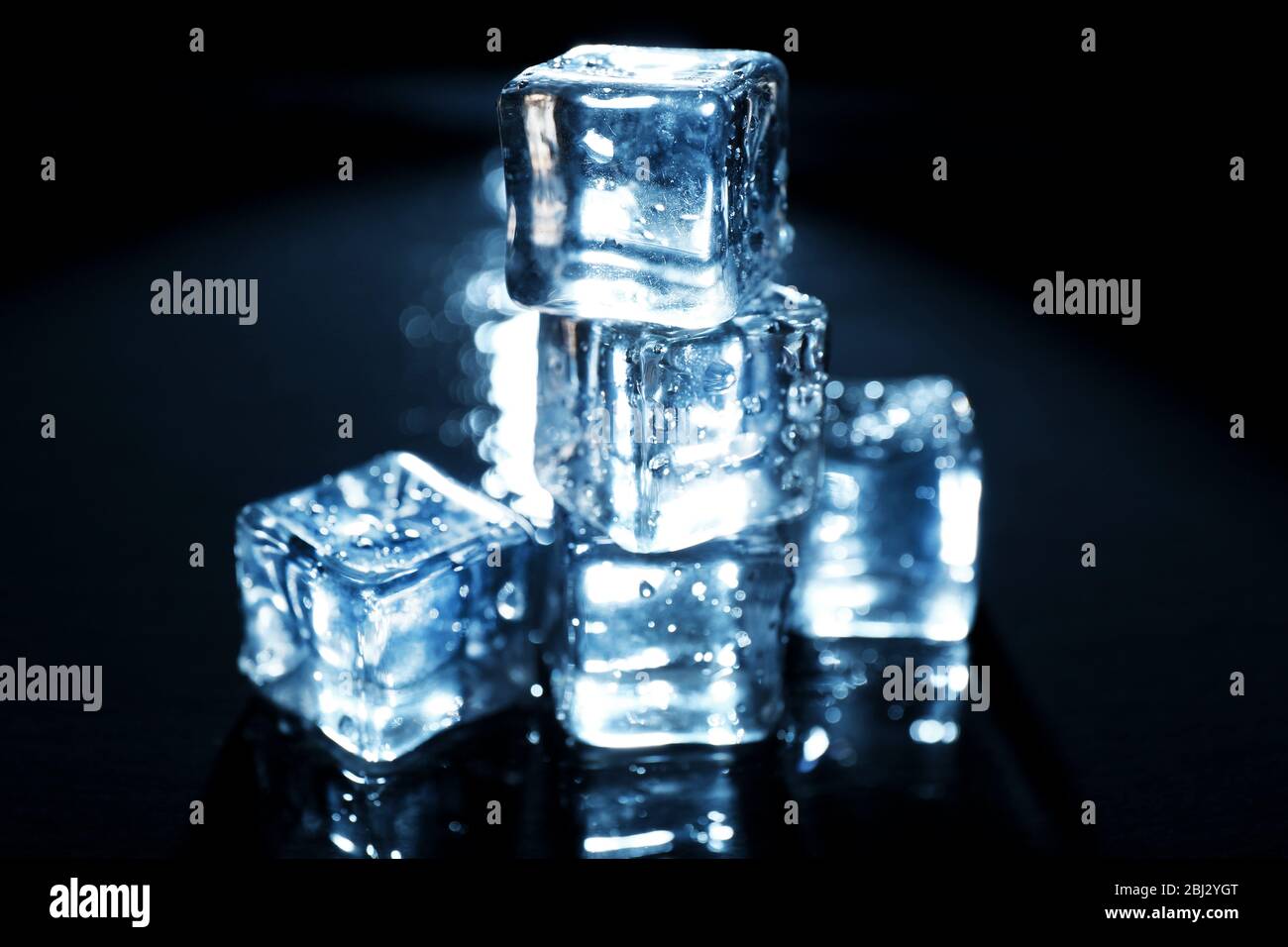 Shining ice cubes under blue light on liquid background Stock Photo - Alamy