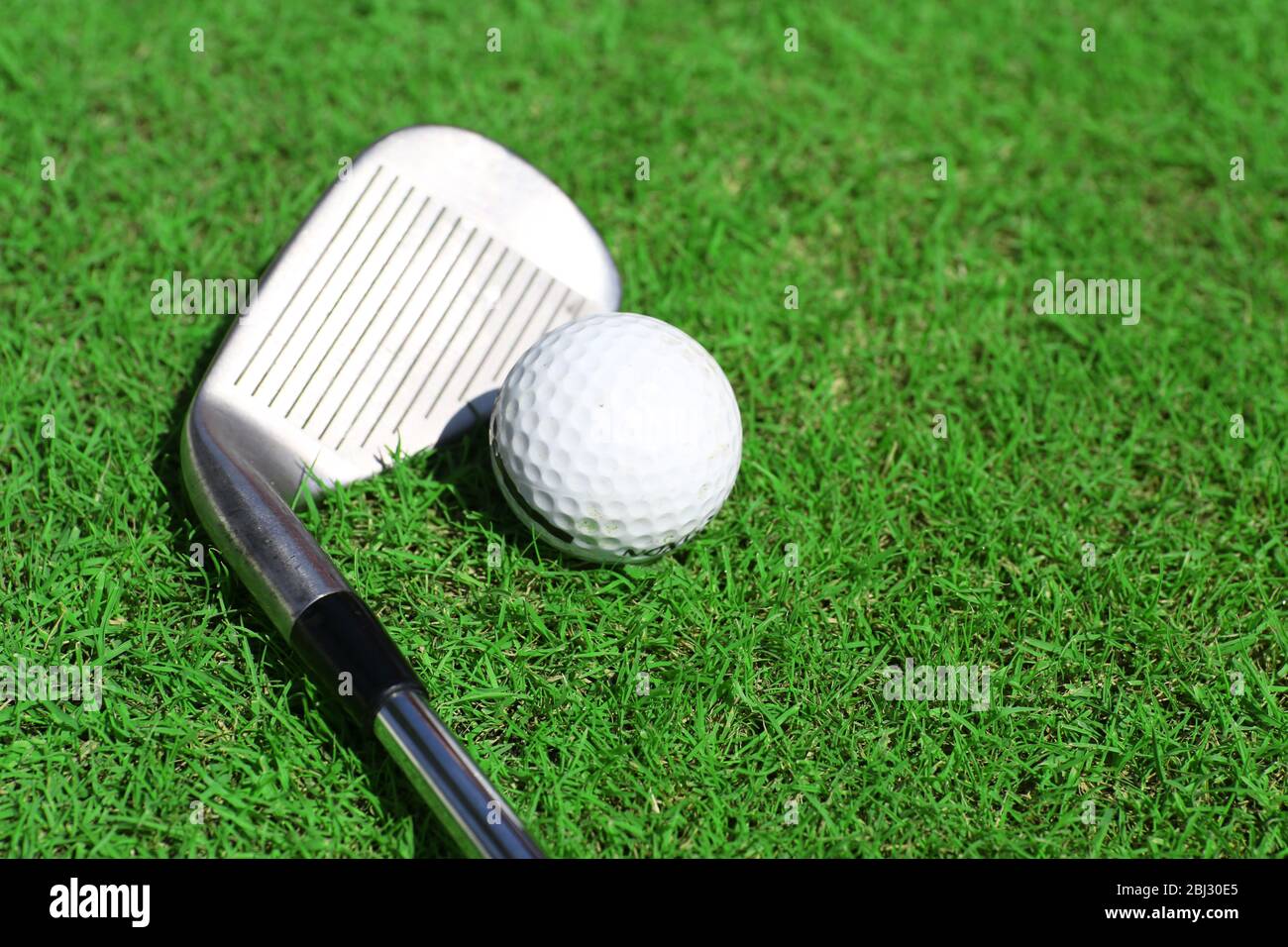 Golf club and ball on a green grass Stock Photo - Alamy