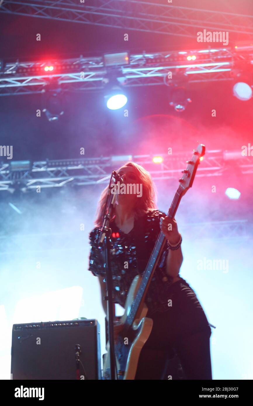 Audience with hands raised at a music festival and lights streaming ...