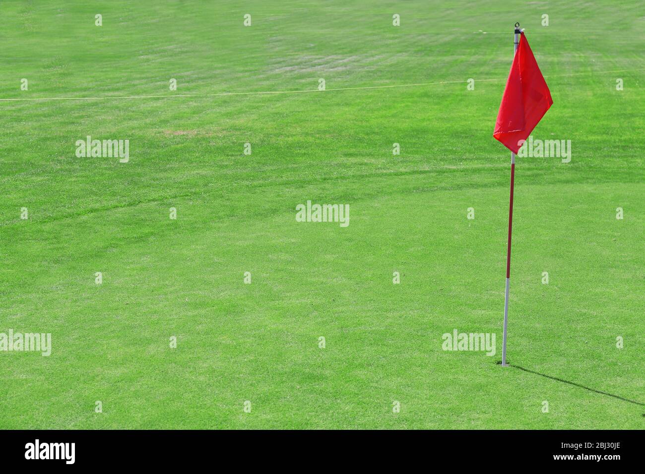 Green golf course with red flag, close up Stock Photo - Alamy