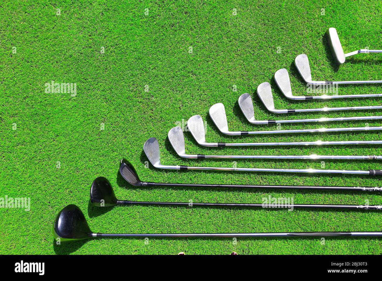Different golf clubs in a row on a green grass Stock Photo - Alamy
