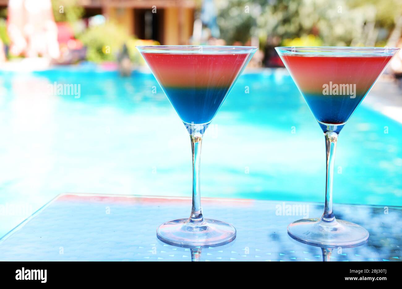 Cocktails on swimming pool background Stock Photo - Alamy