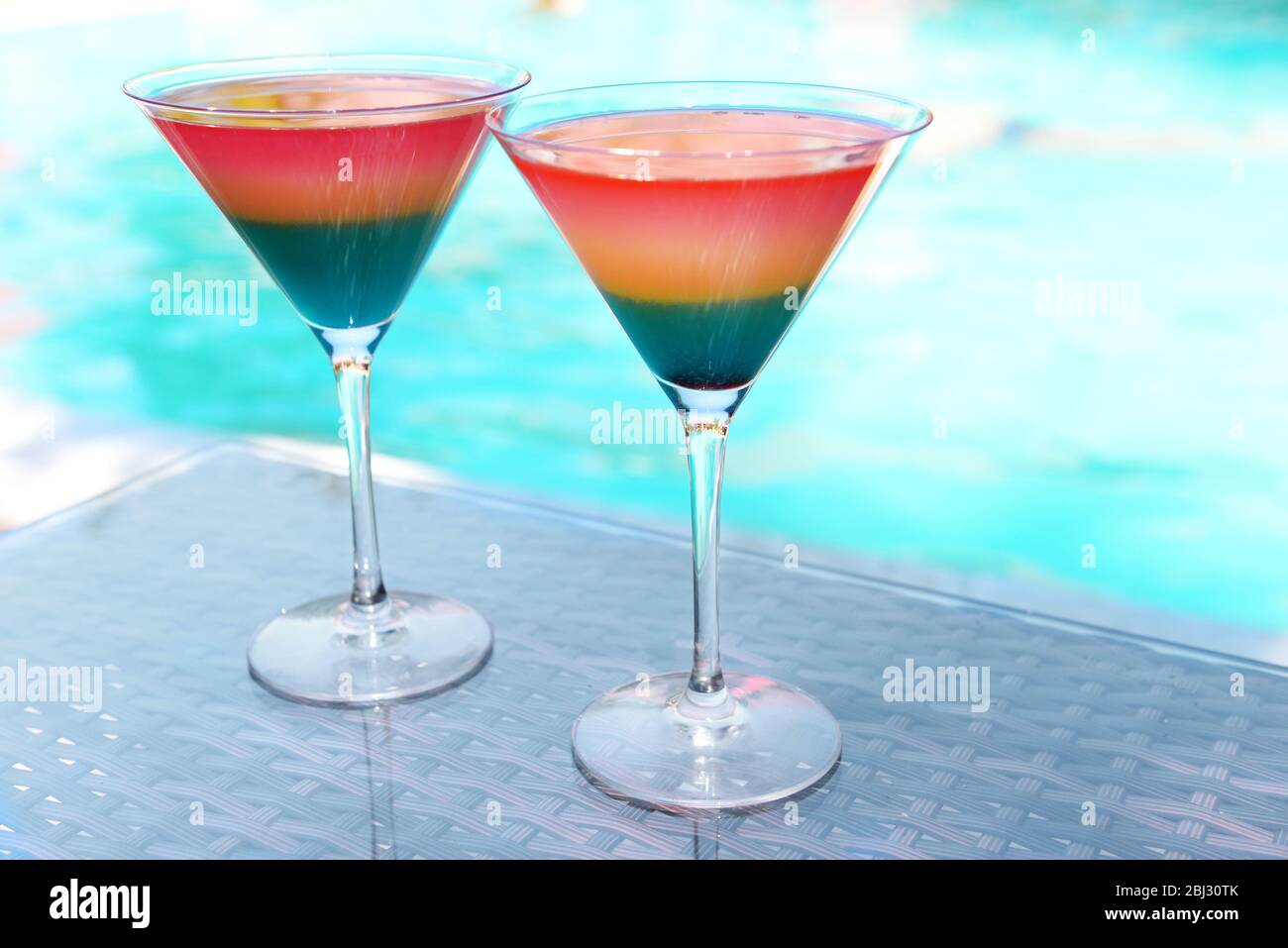 Cocktails on swimming pool background Stock Photo - Alamy