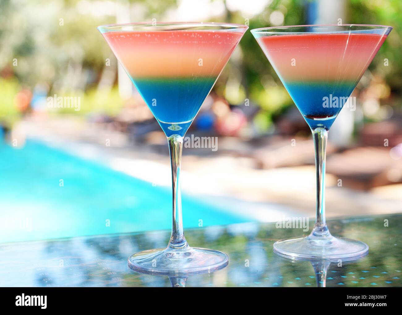 Cocktails on swimming pool background Stock Photo - Alamy