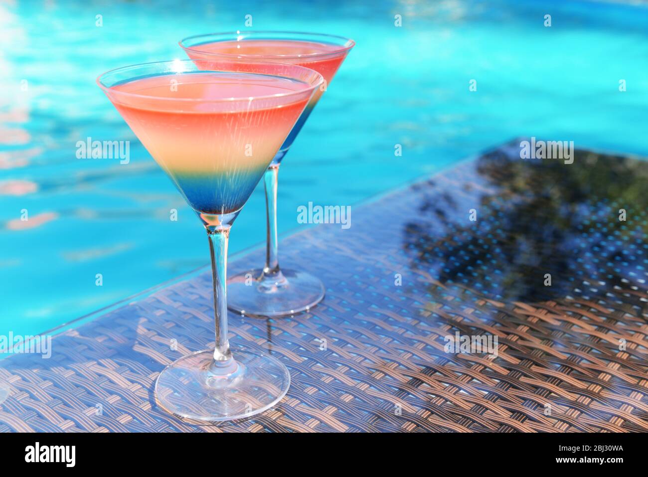 Cocktails on swimming pool background Stock Photo - Alamy