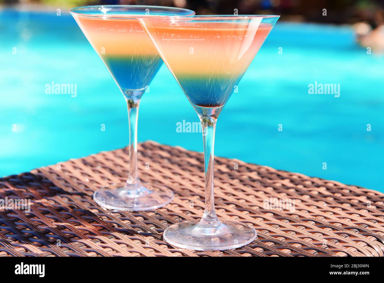 Cocktails on swimming pool background Stock Photo - Alamy