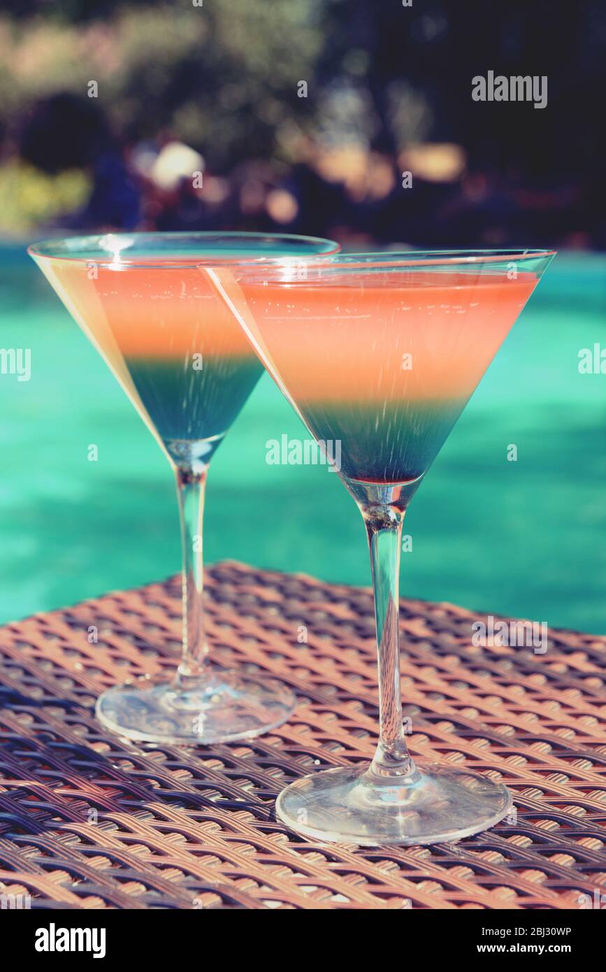 Cocktails on swimming pool background Stock Photo - Alamy