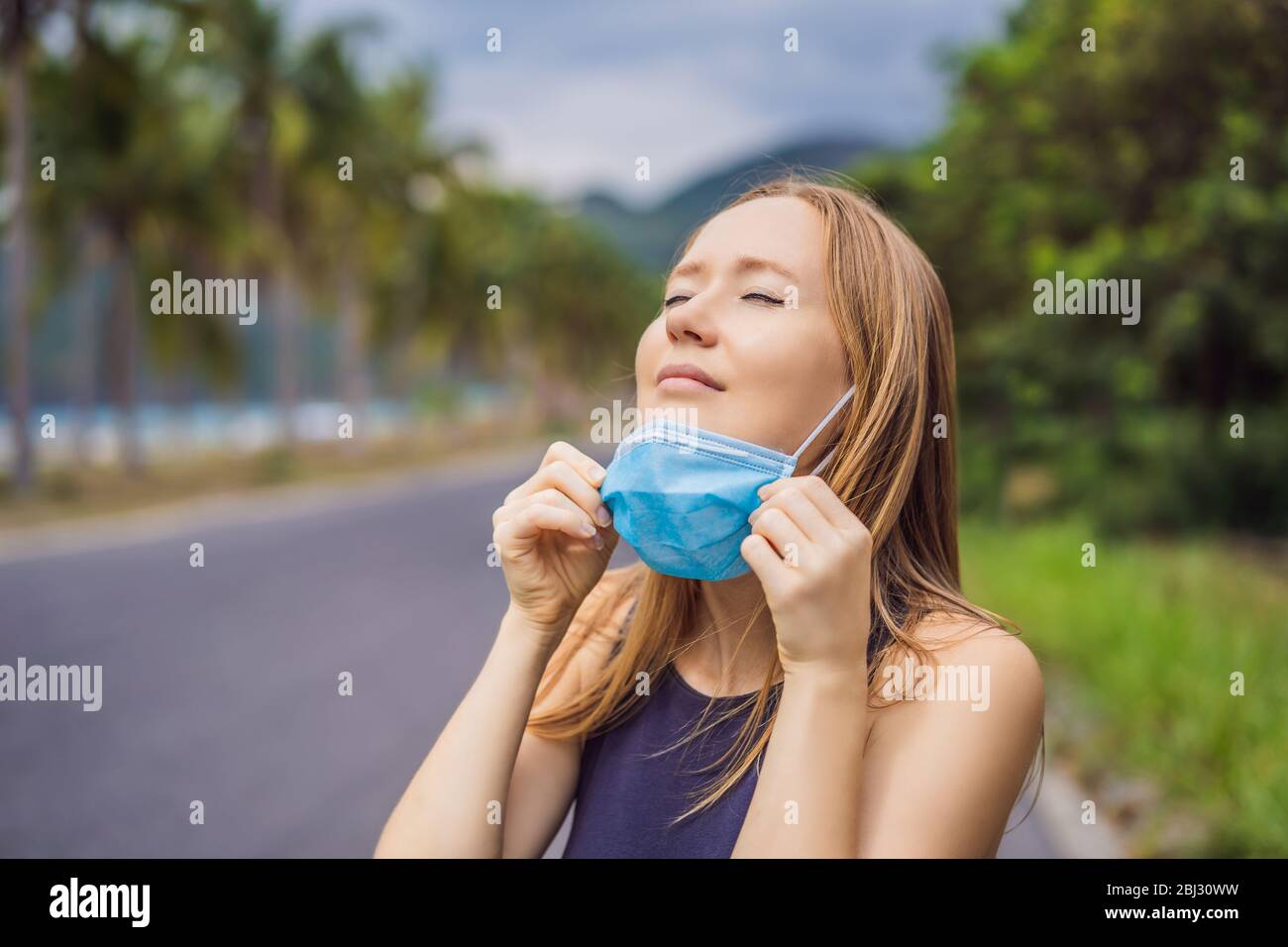 Quarantine is over concept. Woman taking off mask outdoor. We are safe ...