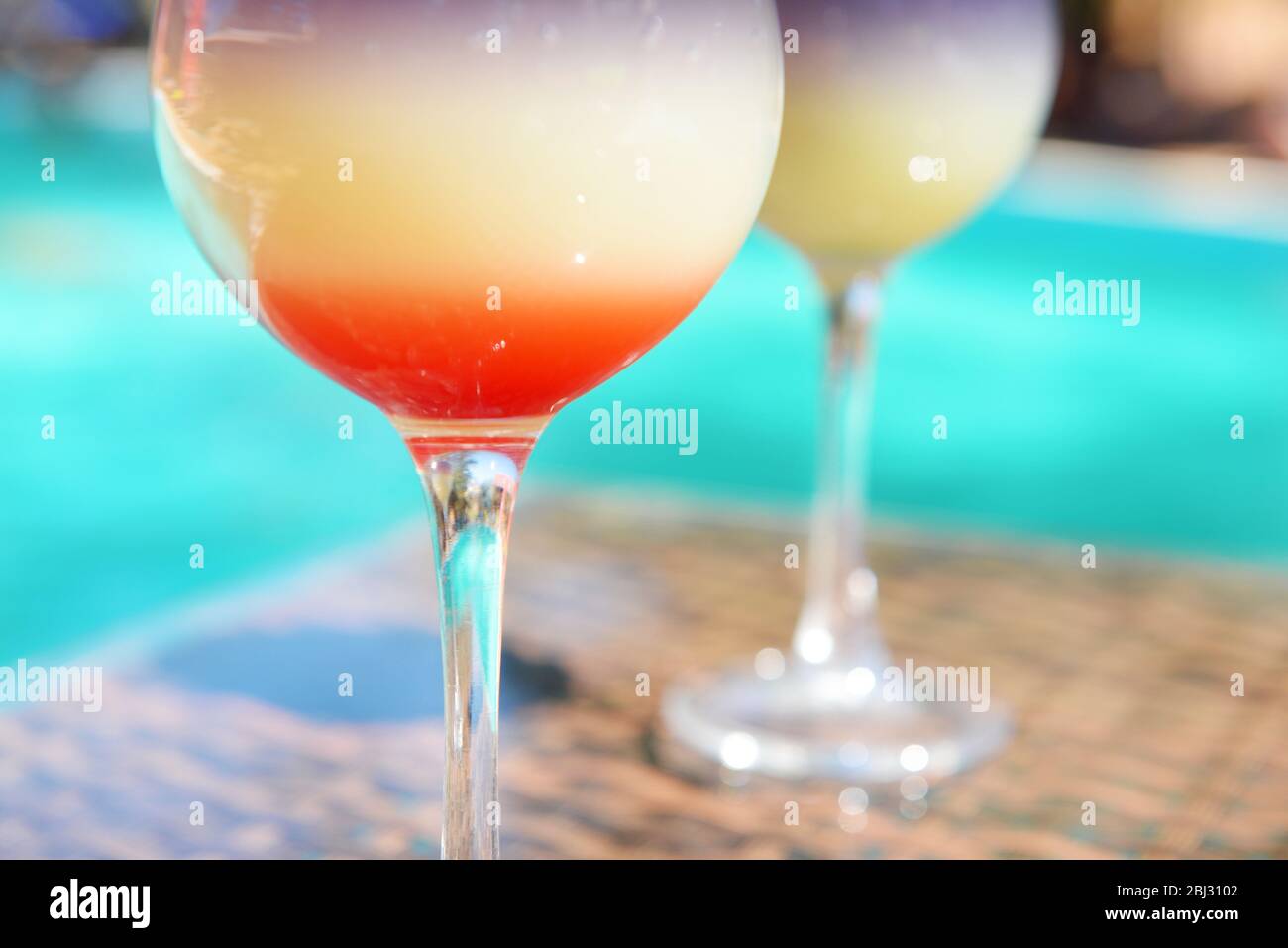 Cocktails on swimming pool background Stock Photo - Alamy