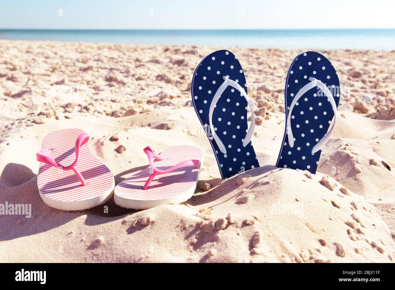 Flip flops on beach sand closeup Stock Photo - Alamy