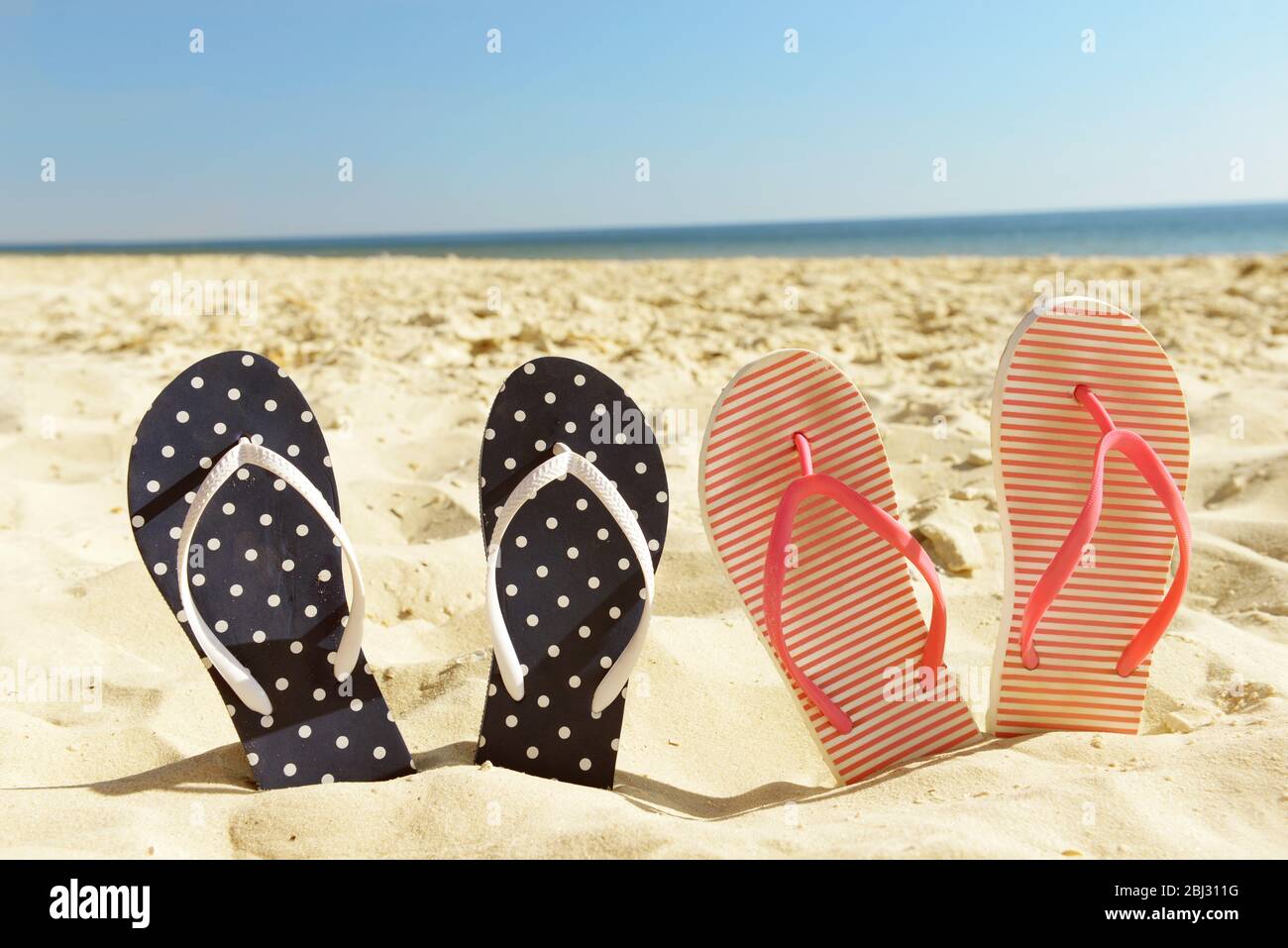 Flip flops on beach sand closeup Stock Photo - Alamy