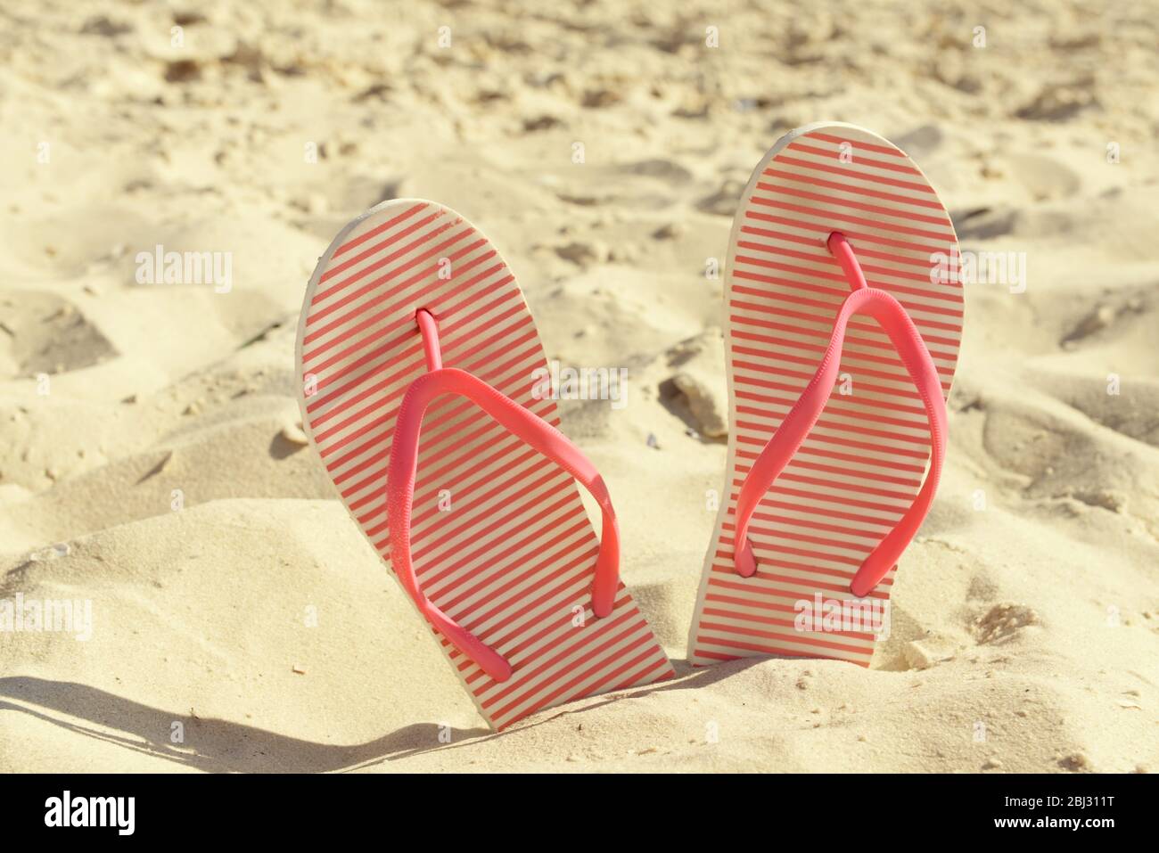 Flip flops on beach sand closeup Stock Photo - Alamy