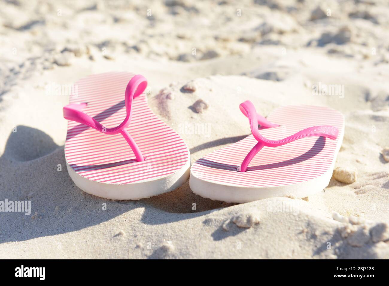 Flip flops on beach sand closeup Stock Photo - Alamy