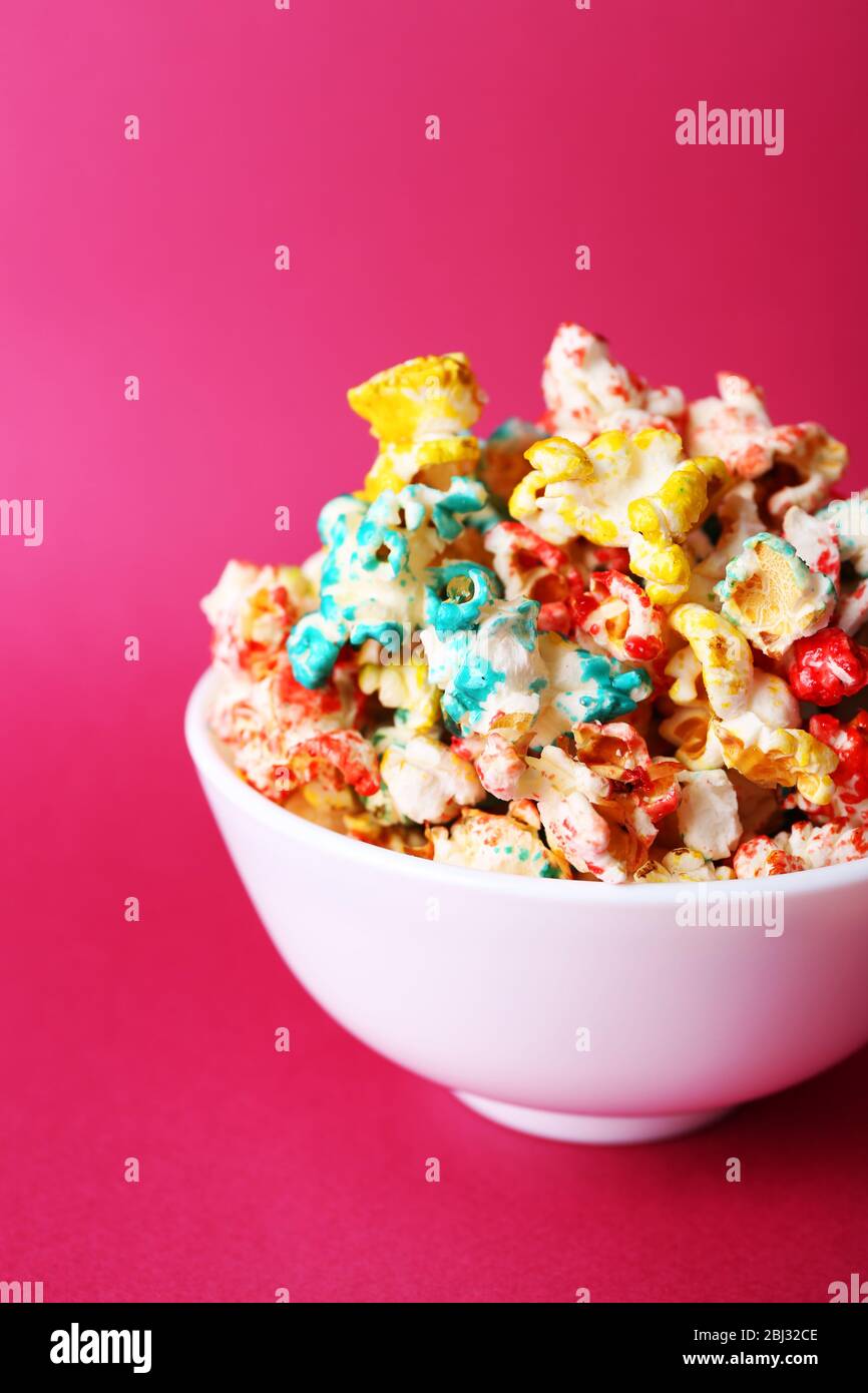 Sweet colourful popcorn on pink background Stock Photo - Alamy