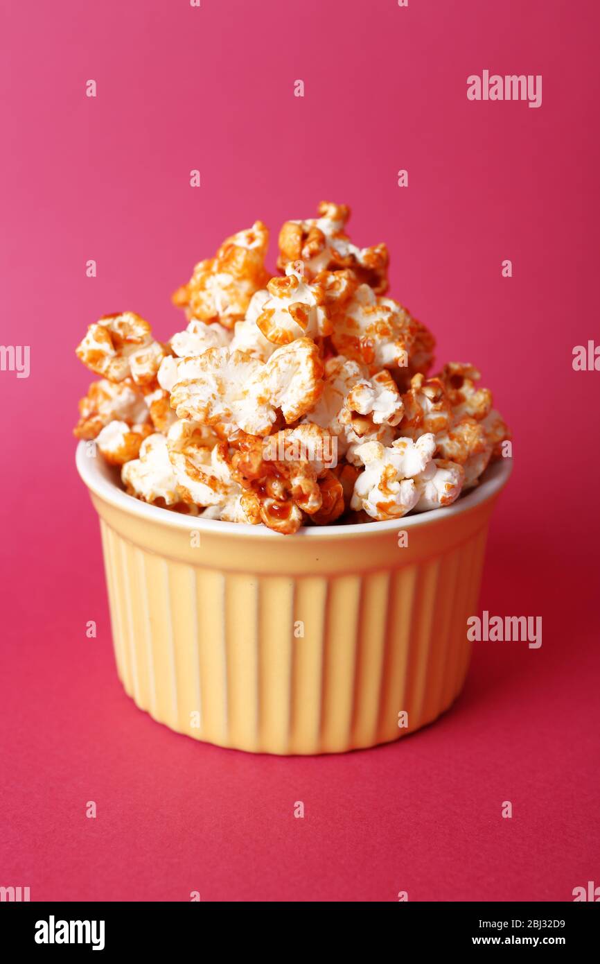 Sweet caramel popcorn on pink background Stock Photo - Alamy
