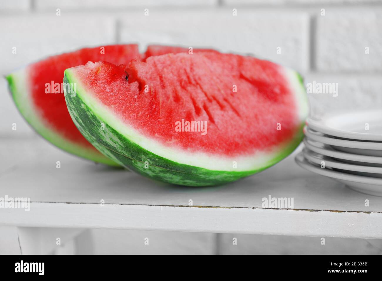 Sliced watermelons on brick wall background Stock Photo - Alamy