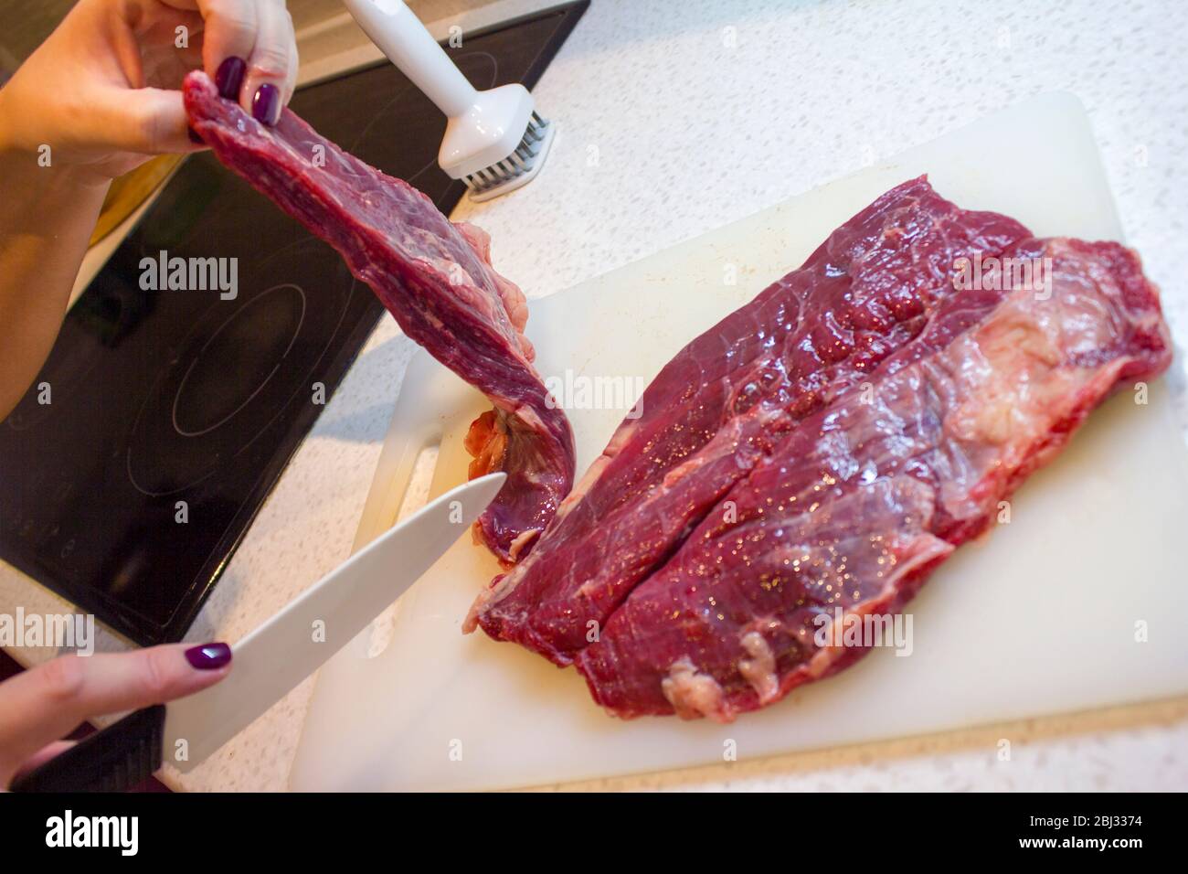 Cutting beef in the kitchen Stock Photo - Alamy