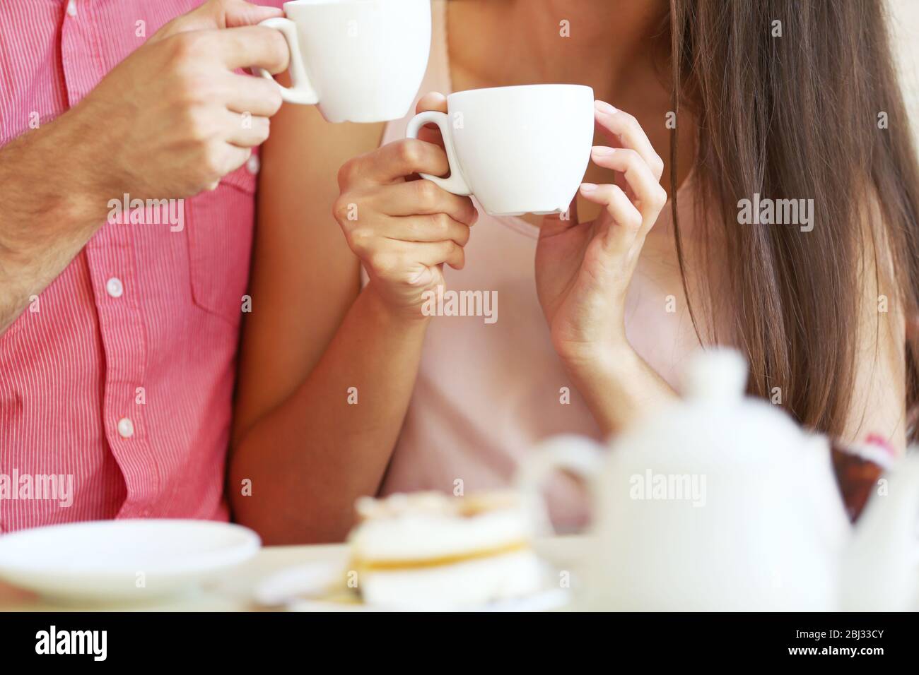 Young couple drinking tea in cafe Stock Photo - Alamy