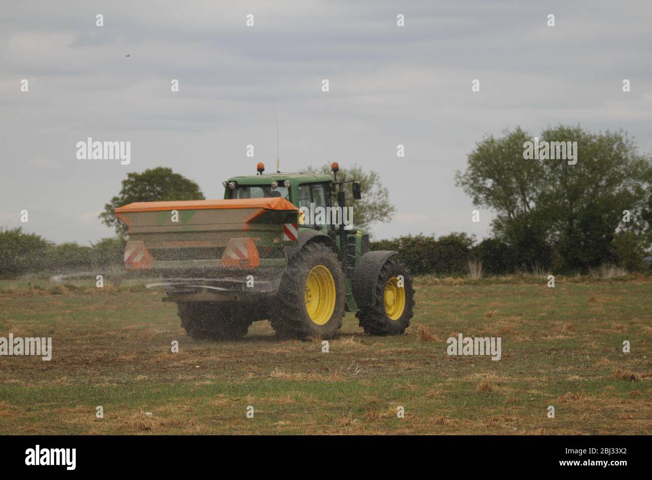 Tractor fertilizing fields Stock Photo - Alamy